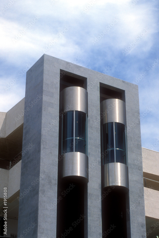 Two Modern Steel & Glass Tubular Elevators on Exterior of New Building ...