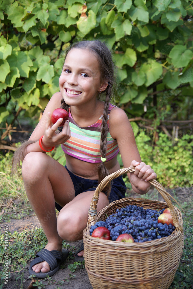 Preteen girl with basket full of organic grapes and apples Stock Photo ...