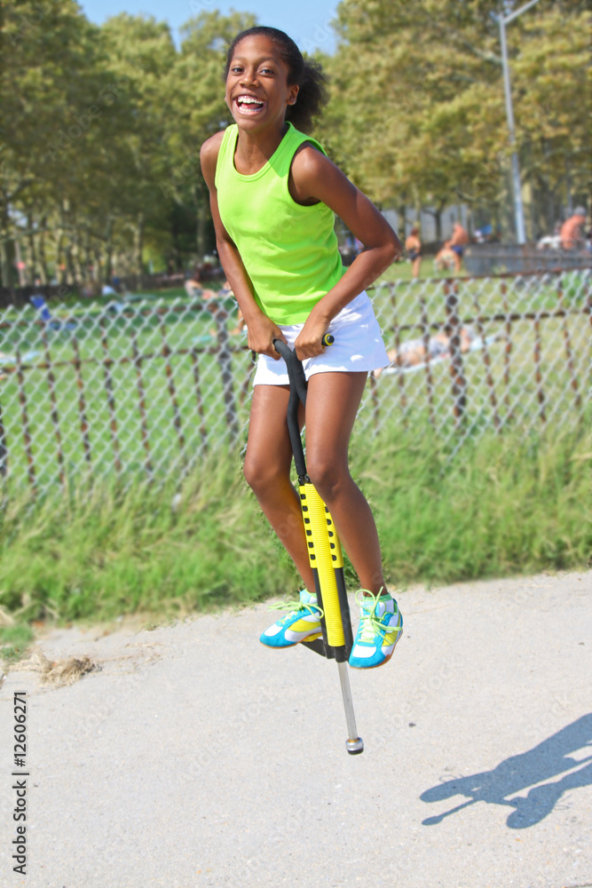 Girl jumping on pogo stick Stock Photo | Adobe Stock