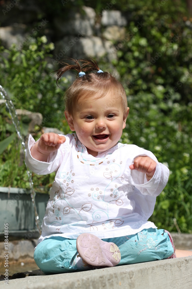 Photo Stock bébé fille heureuse en position assise | Adobe Stock