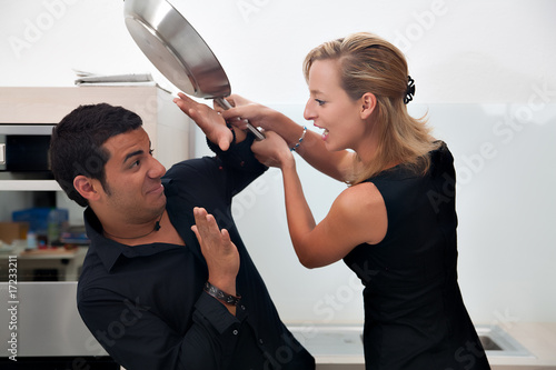 a woman beating a man with a pan - Buy this stock photo and explore ...