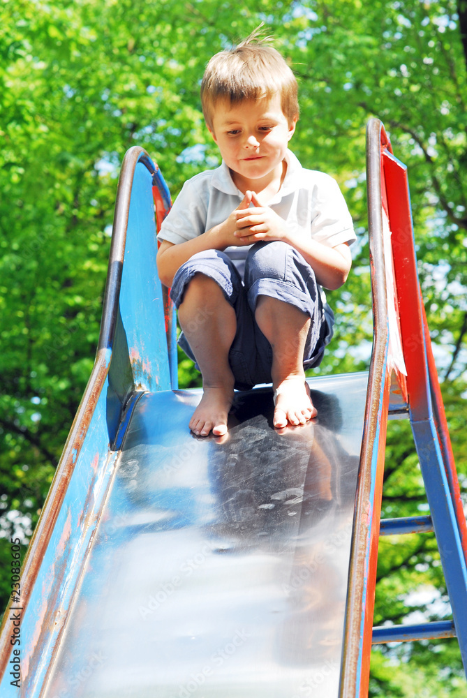 Junge sitzt oben auf der Rutsche Stock Photo | Adobe Stock