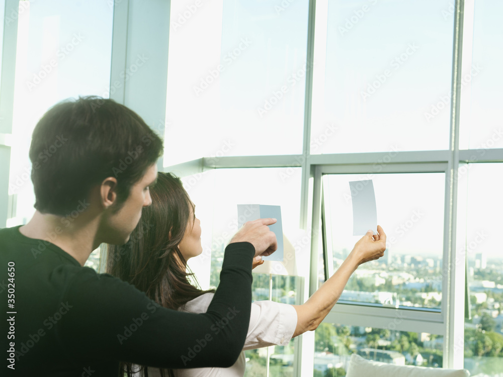 Couple looking at color swatches near window Stock Photo | Adobe Stock