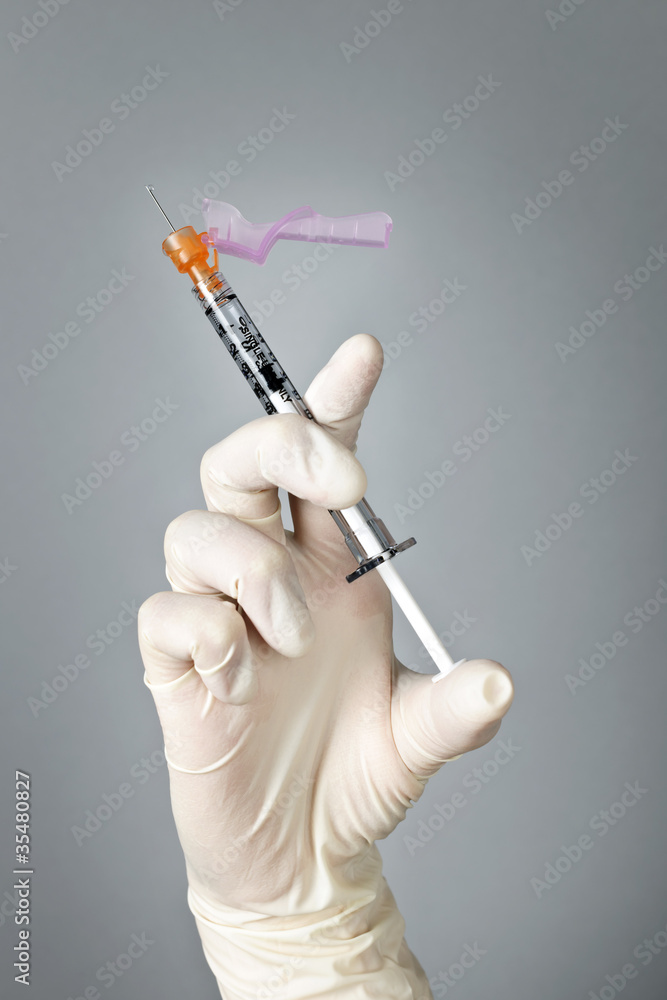 Syringe held by gloved hand Stock Photo | Adobe Stock