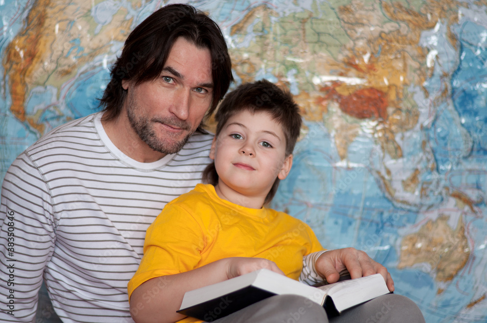 Dad and son reading a book on a map of the world Stock Photo | Adobe Stock