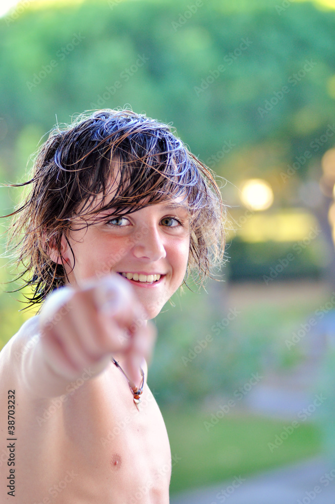 Photo Stock Jeune ado torse nu qui désigne du doigt | Adobe Stock