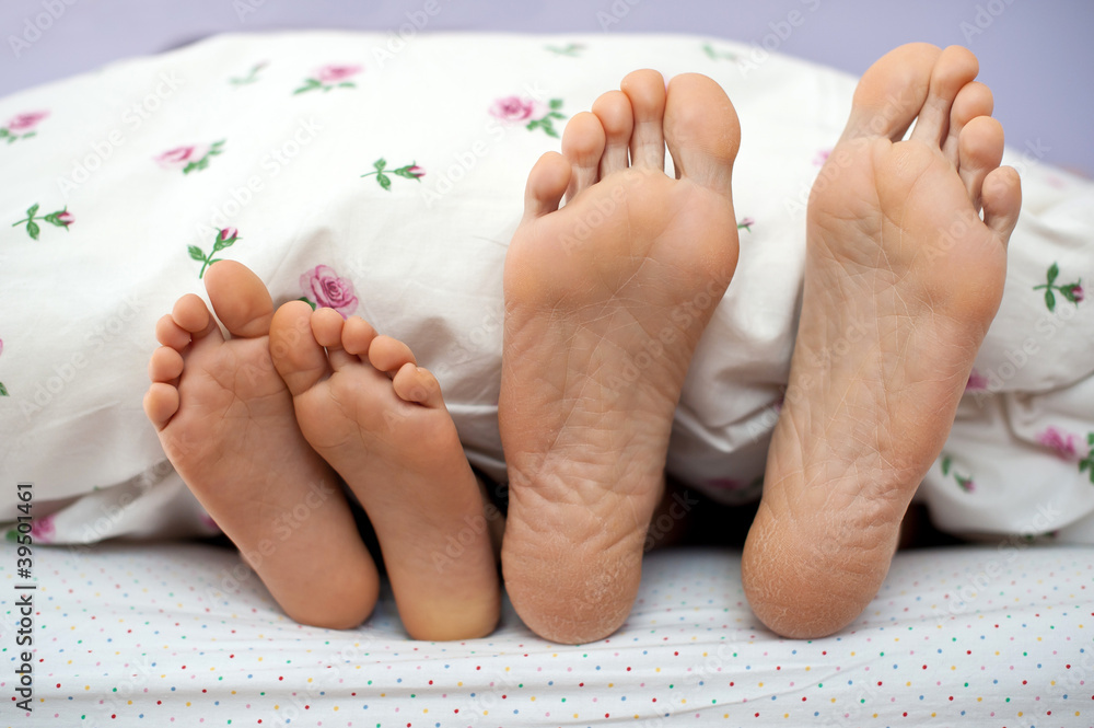 Mother and son bare feet in bed. Stock Photo | Adobe Stock