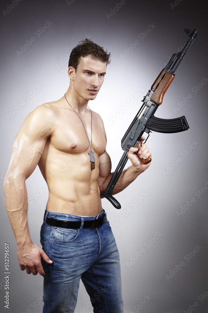 Power muscle man with AK-47 gun posing in studio Stock Photo | Adobe Stock