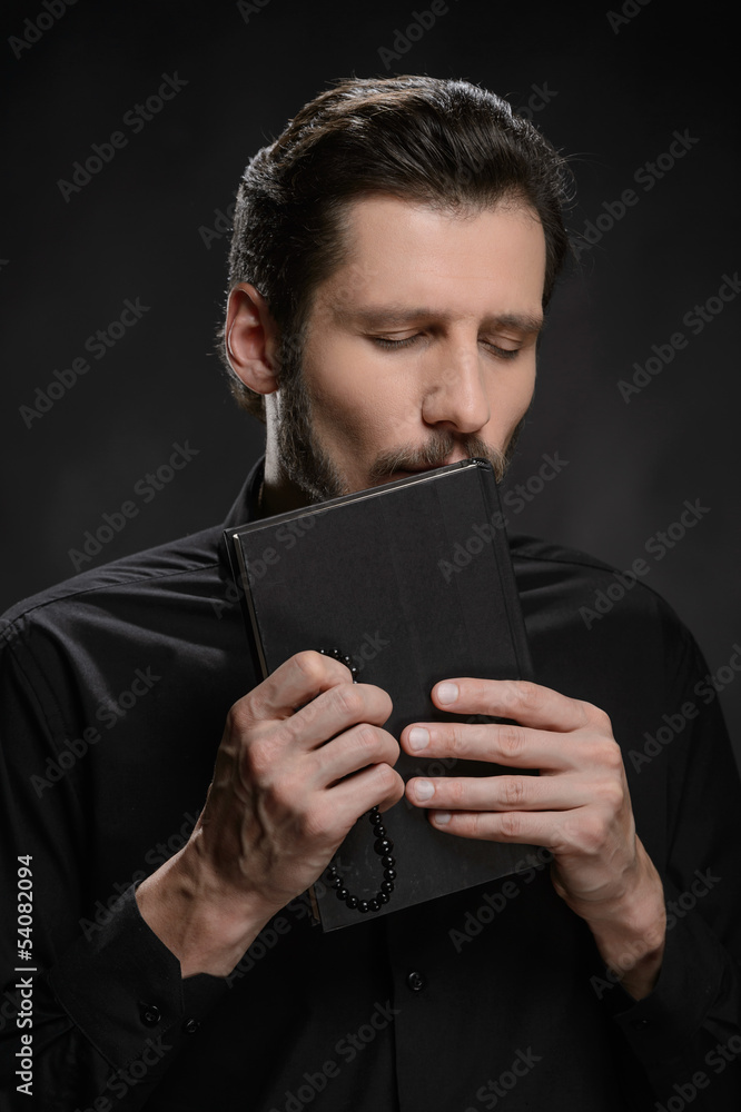 Priest kissing the Holy Bible. Portrait of priest kissing the Ho Stock ...