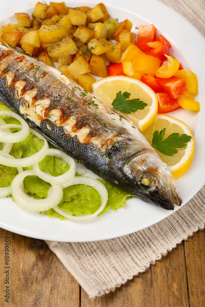 Delicious grilled fish on plate on table close-up Stock Photo | Adobe Stock