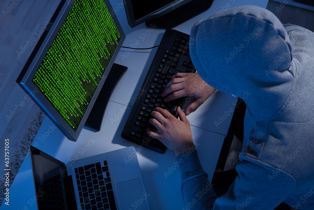 Hacker In Hooded Jacket Using Computer At Table の Stock フォト | Adobe Stock