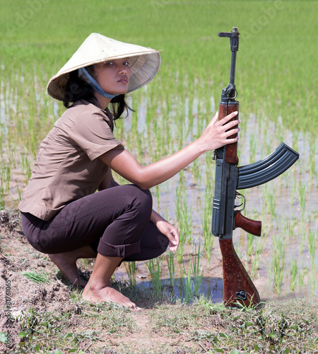 Asian woman with a machine gun in a paddy field Stock Photo | Adobe Stock