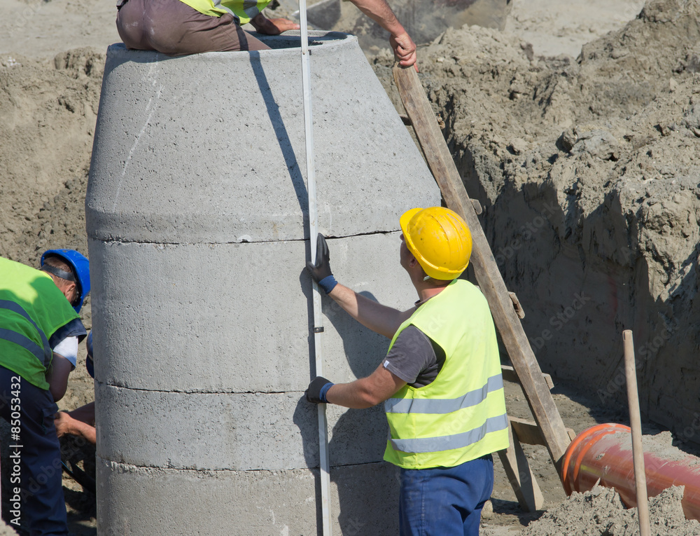 Construction workers leveling sewer vault structure installing depth ...