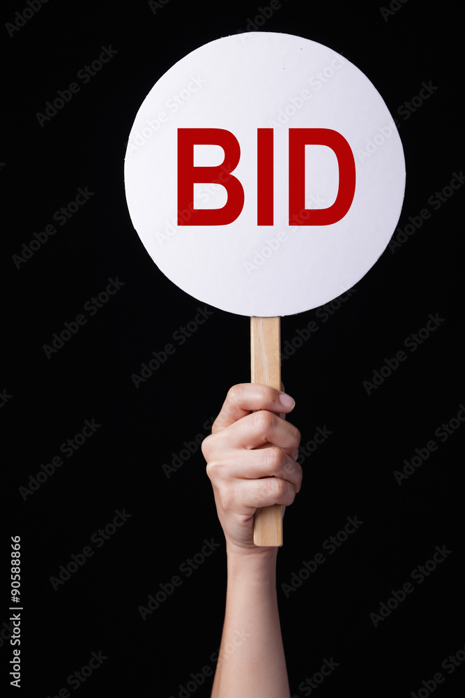 A hand holding an auction paddle Stock Photo | Adobe Stock