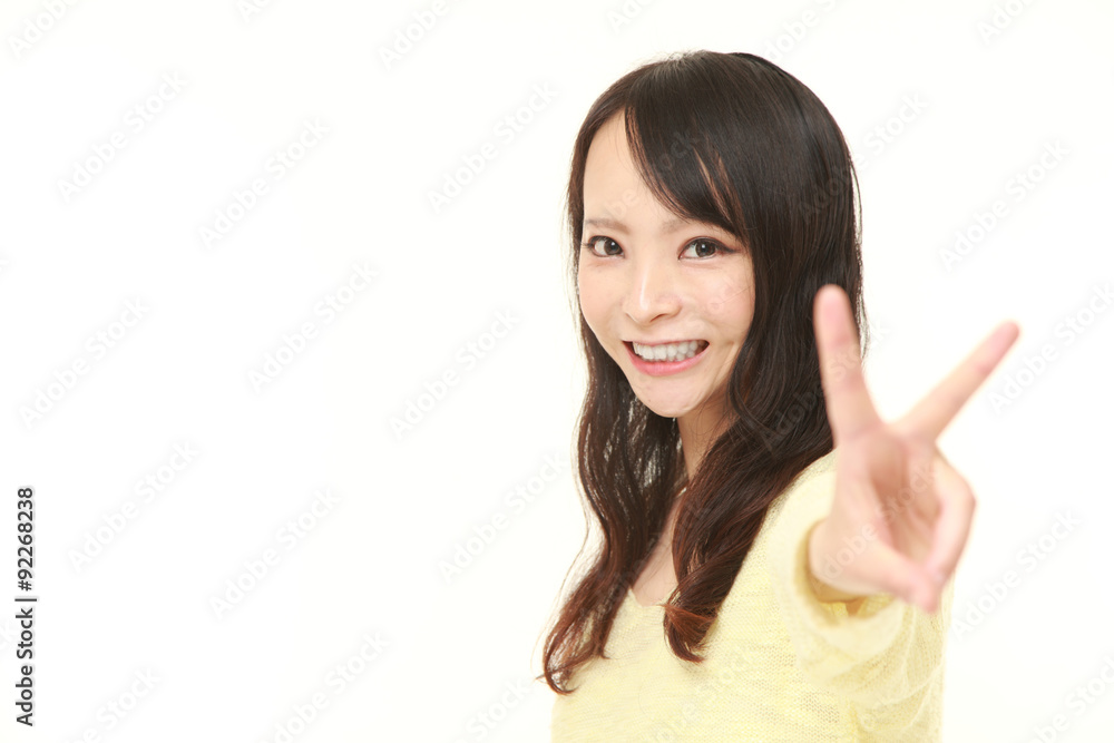 young Japanese woman showing a victory sign Stock Photo | Adobe Stock