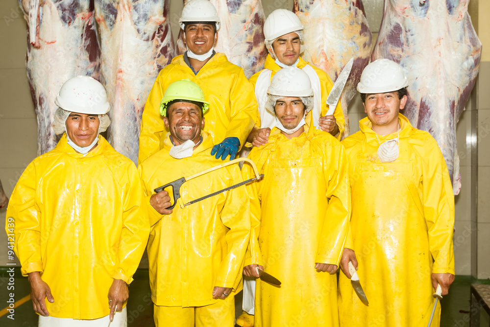 Slaughterhouse team of six skilled butchers posing with their specific ...