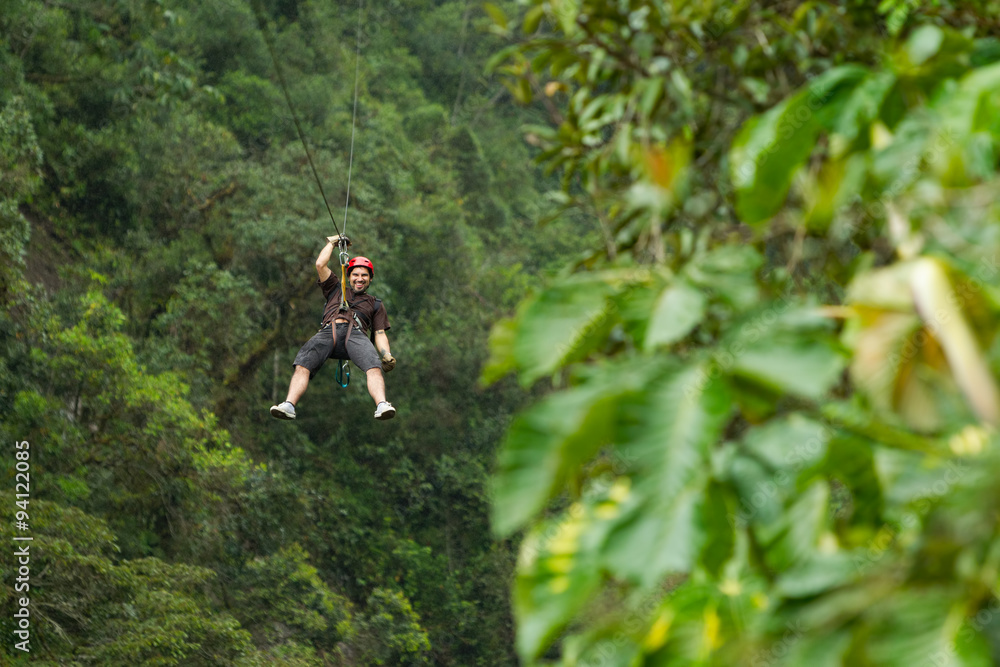 Thrill-seekers zip through the lush canopy of an Ecuadorian rainforest ...