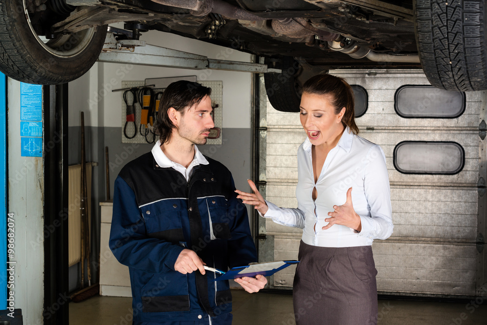Car mechanic with angry female customer Stock Photo | Adobe Stock