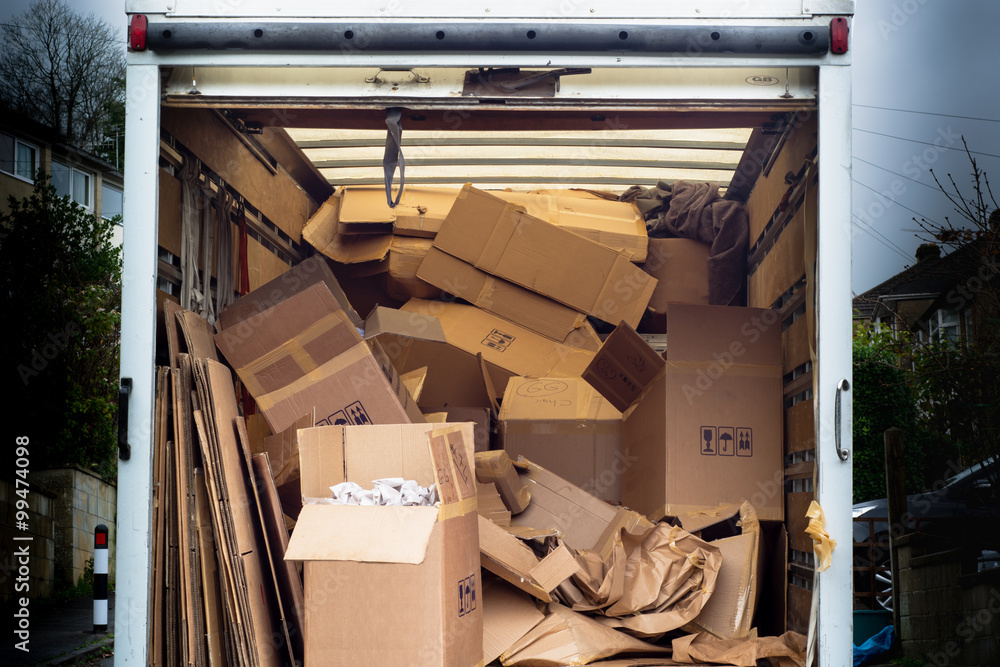 Removal van with untidy boxes dumped inside. A removal lorry is filled ...