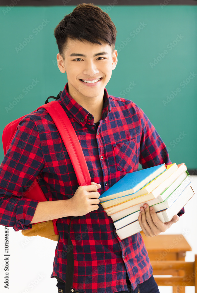 Smiling male student standing in classroom Stock Photo | Adobe Stock