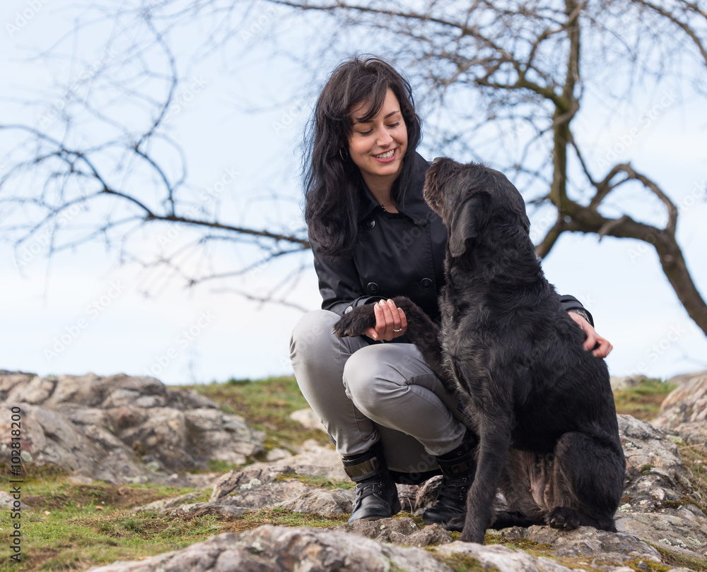 Beautiful girl with mutt black dog on mountains Stock Photo | Adobe Stock