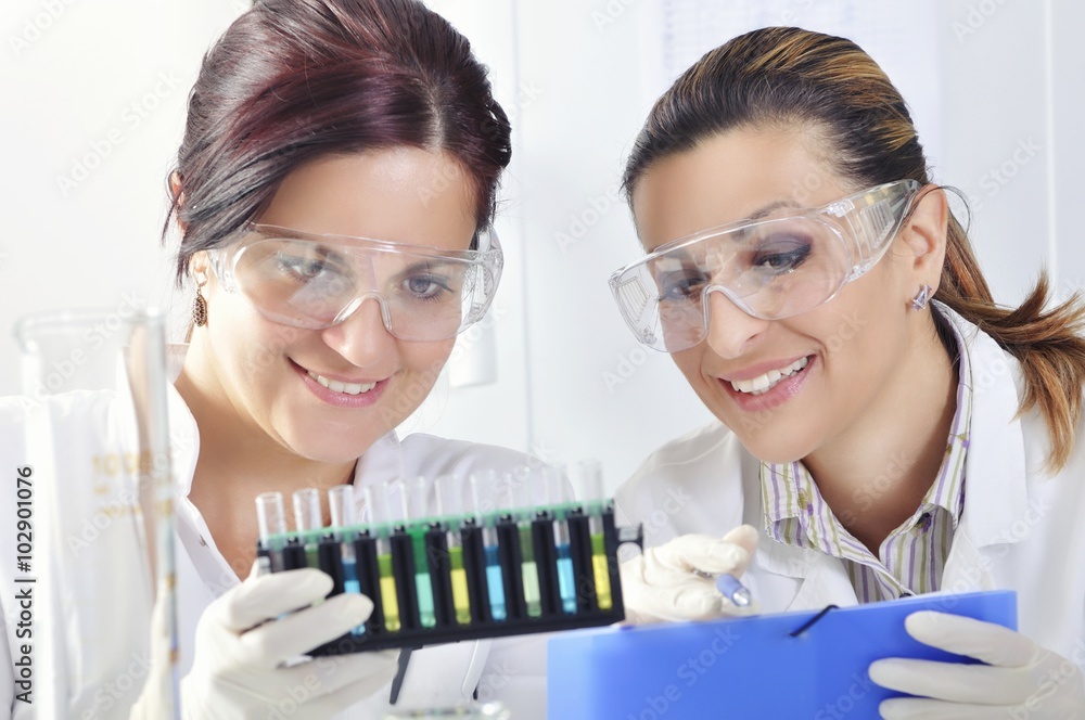 Attractive young PhD students scientists observing the blue, yellow and ...