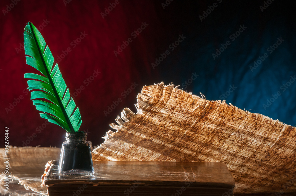 Green quill pen and a backlit papyrus sheet with its particular texture ...