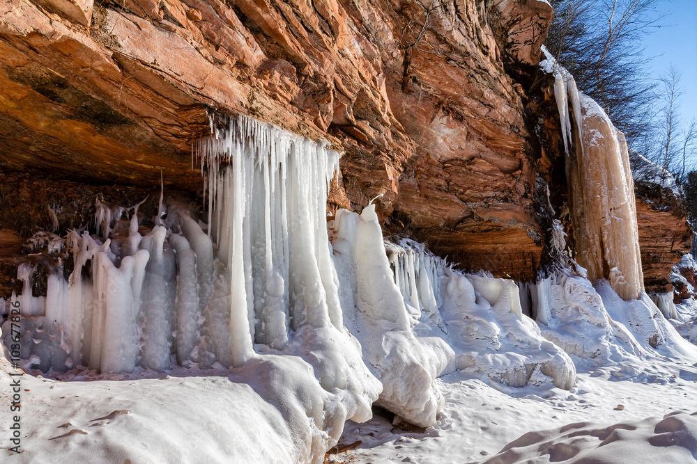 Strange ice formations hang from shoreline sandstone cliffs on ...