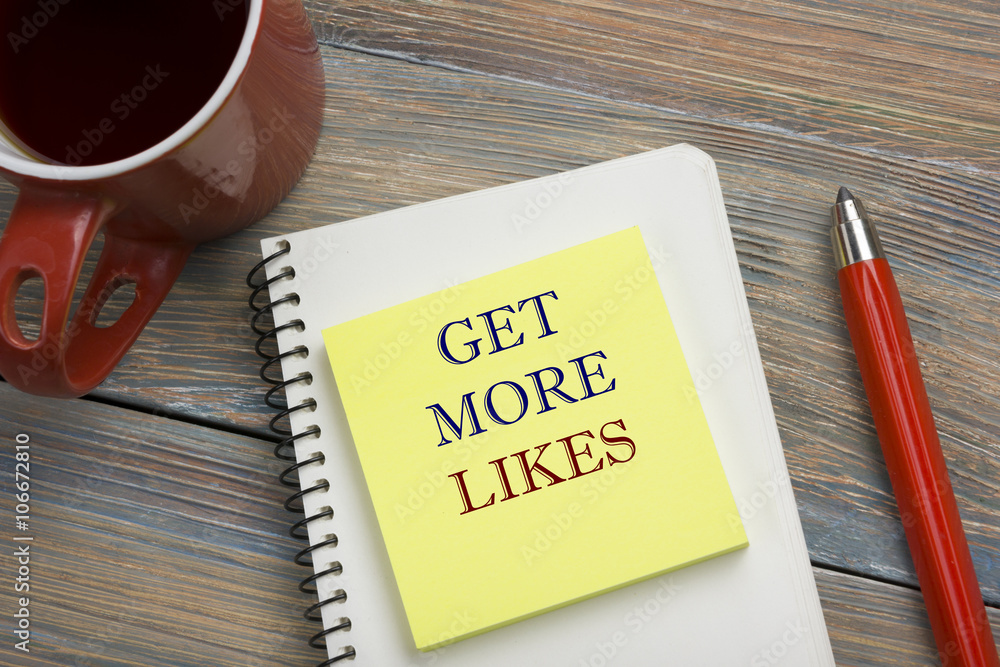 Get More Likes concept. Notebook page with text, red pencil and coffee ...