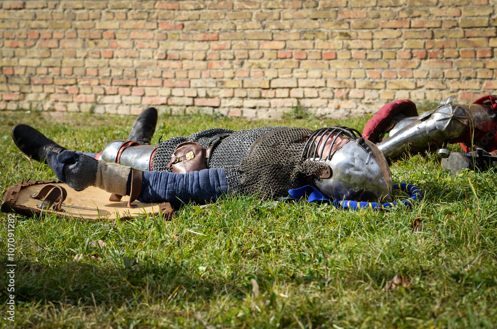 Medieval knight lying on the grass. Outdoor photo in vintage style ...