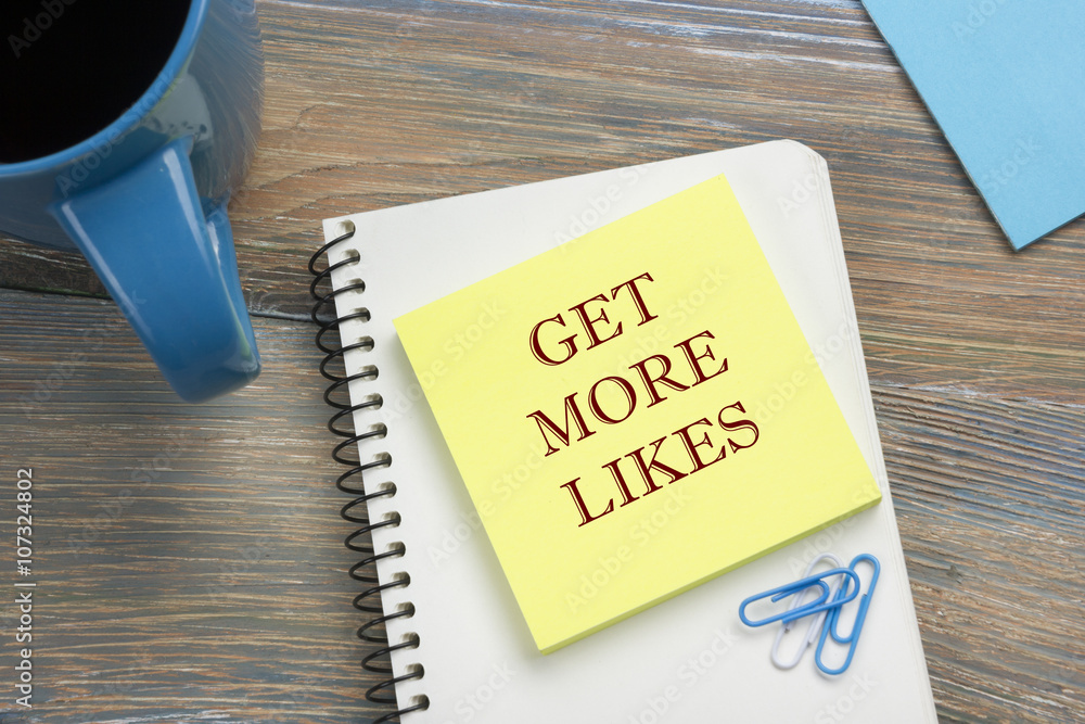 Get More Likes concept. Notebook page with text, red pencil and coffee ...