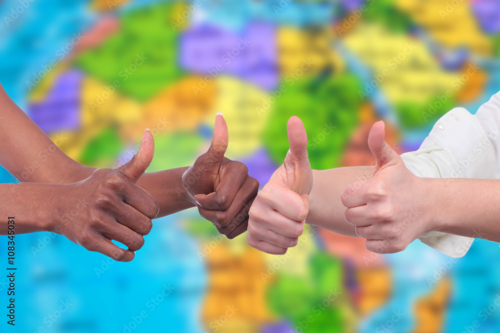 Weiße und schwarze Hände halten Daumen hoch vor weltkarte Stock Photo ...