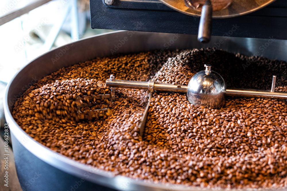 Freshly roasted coffee beans from a large roaster in the cooling ...