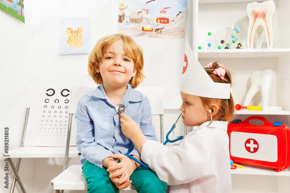 Little doctor examining boy with stethoscope Stock Photo | Adobe Stock