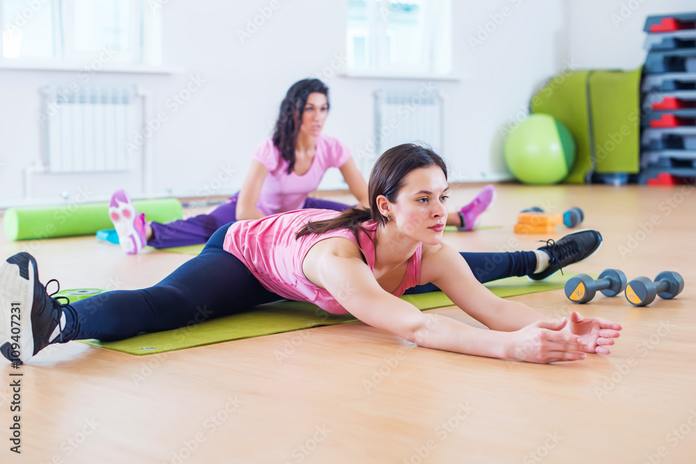 Woman doing cross split exercise working out her hip abductor muscles ...