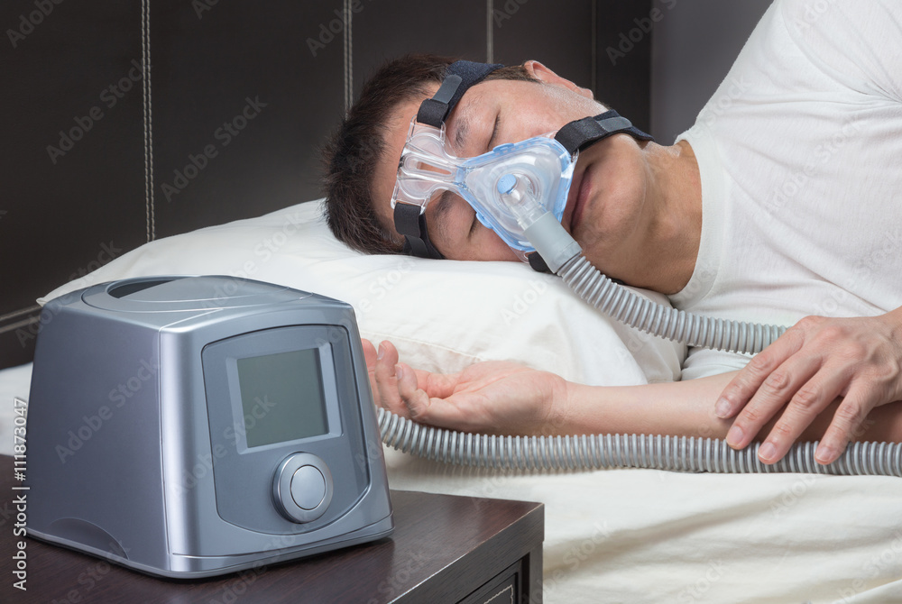Asian man with sleep apnea using CPAP machine Stock Photo | Adobe Stock
