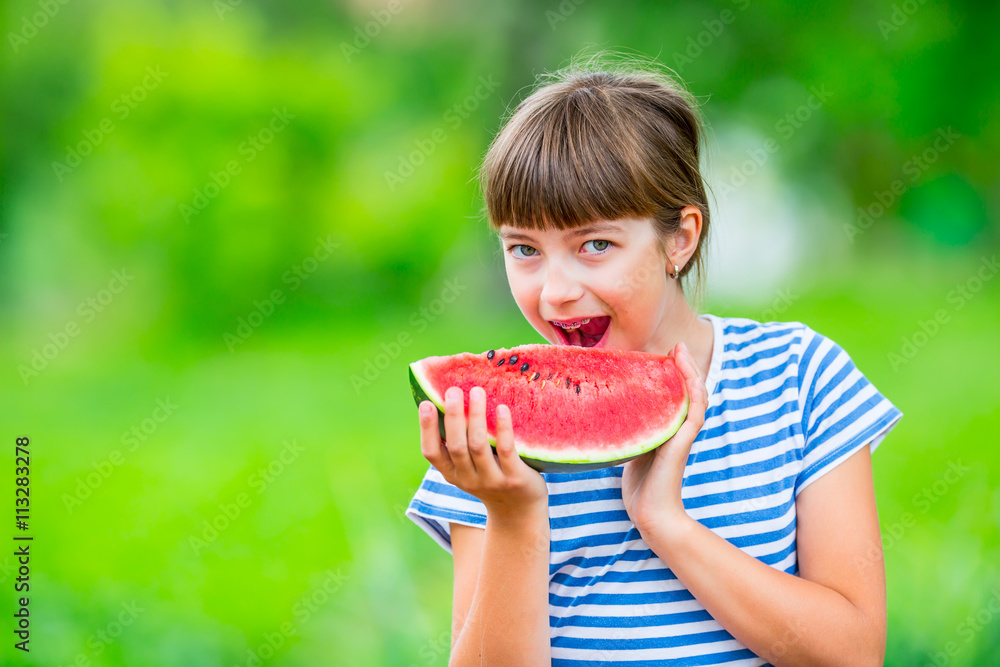 Child eating watermelon. Kids eat fruits in the garden. Pre teen girl ...