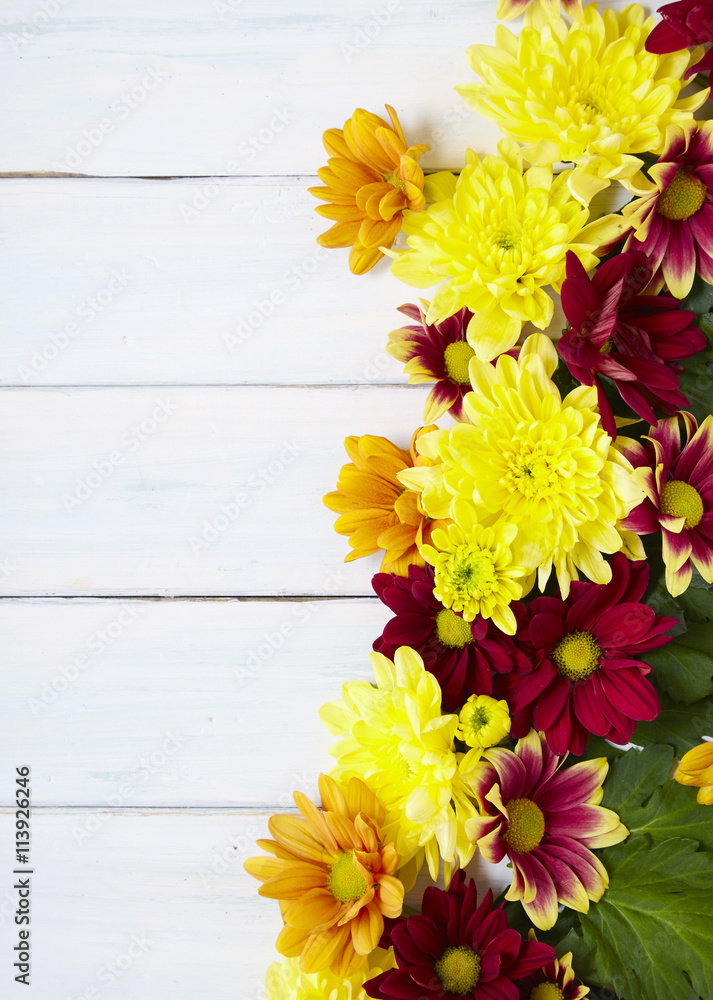 Floral border - Red, yellow and orange flowers and leaves arranged on a ...