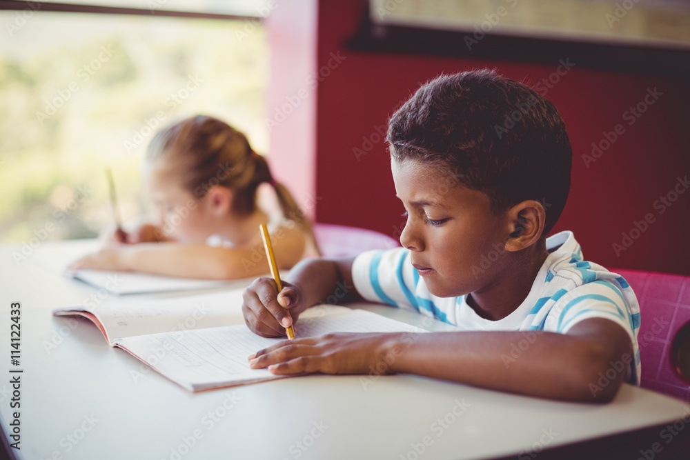 School kids doing homework in classroom Stock Photo | Adobe Stock