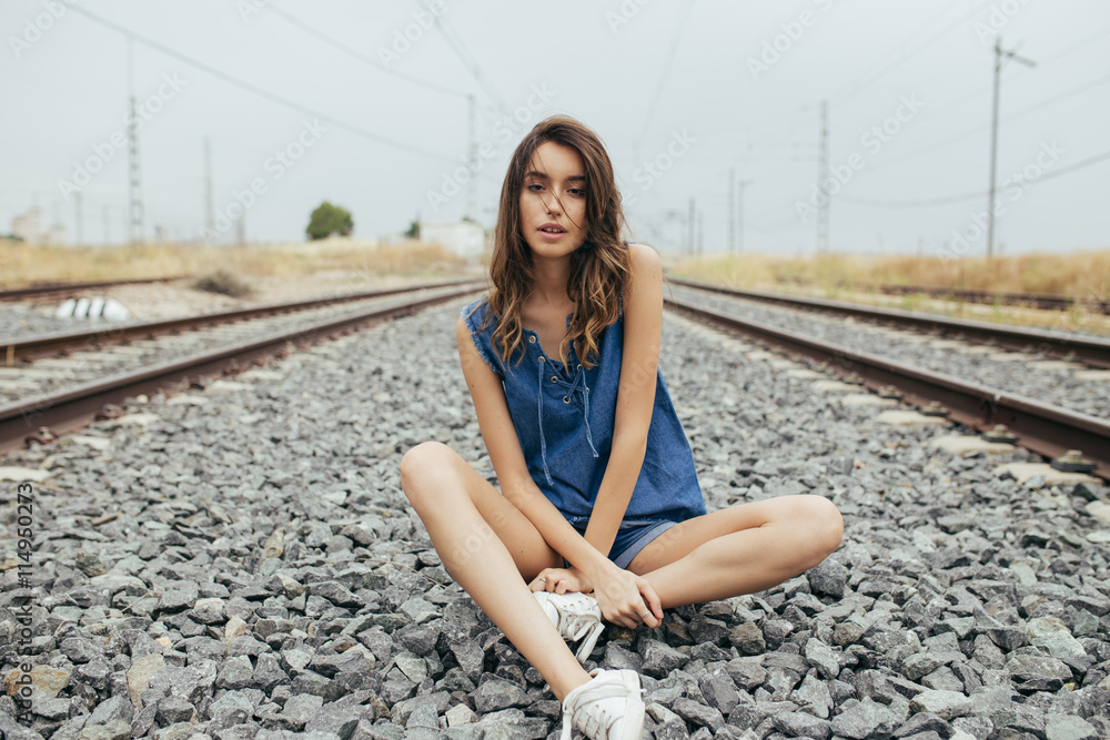 Beautiful young girl shitting on the railway. Stock Photo | Adobe Stock