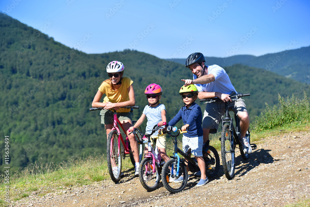 Family on a biking day, parents pointing at scenery Stock Photo | Adobe ...