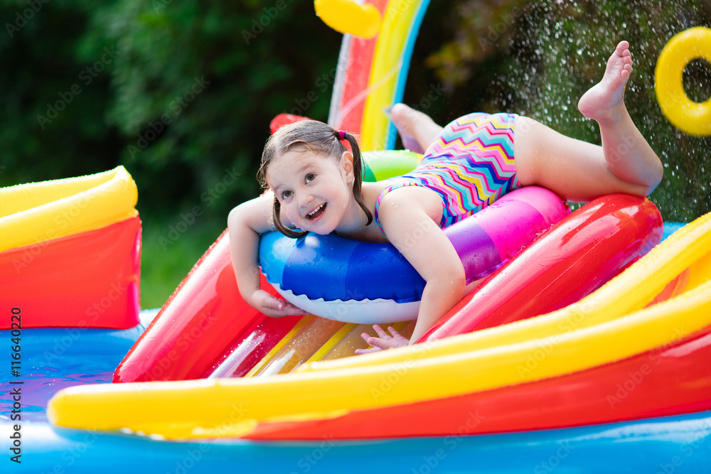 Little girl in garden swimming pool Stock Photo | Adobe Stock