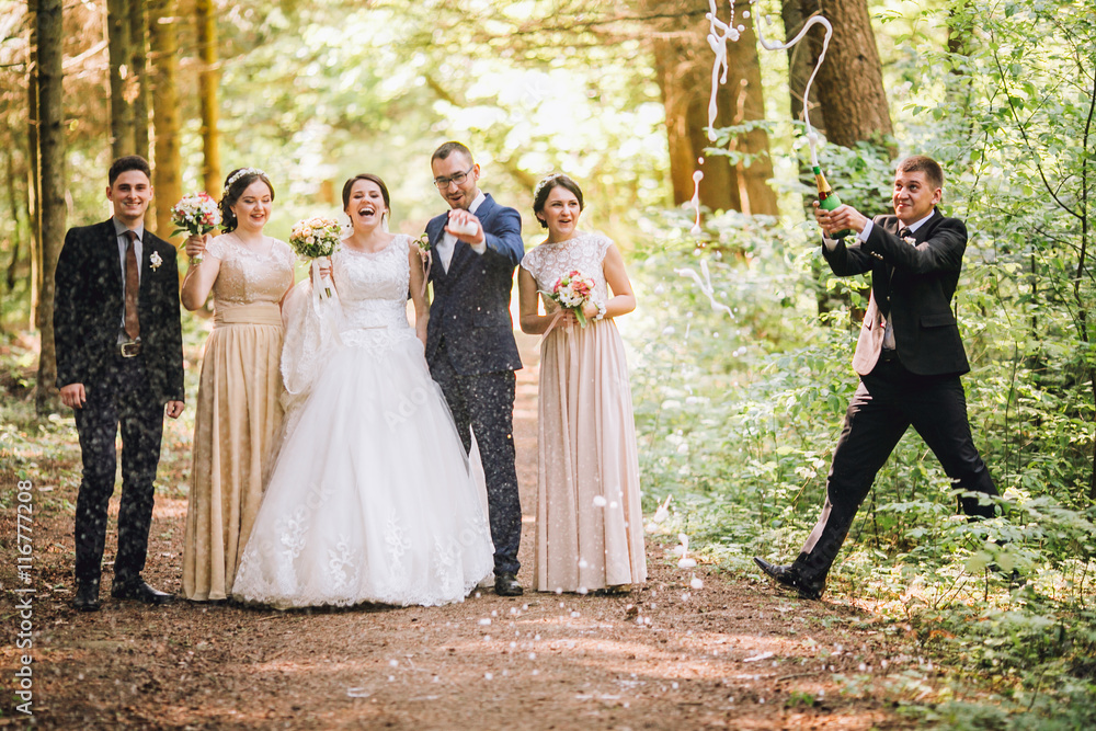 bride and groom with happy groomsmen and bridesmaids having fun and ...