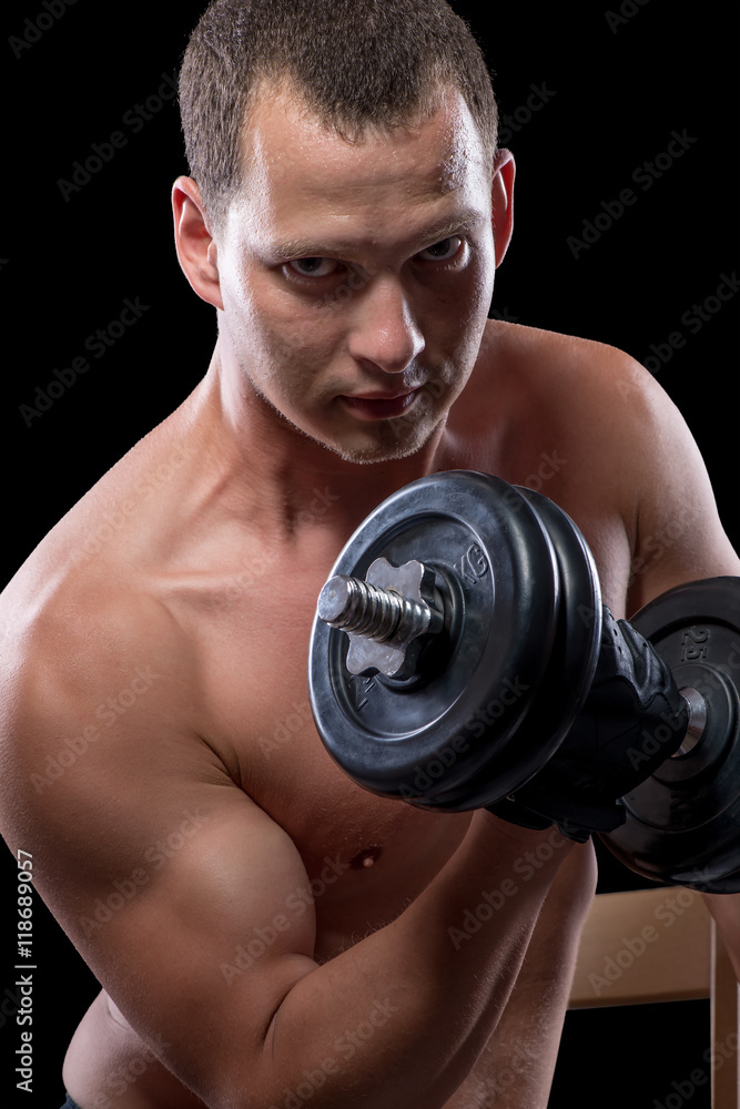 bodybuilder looking into the camera and raises dumbbell Stock Photo ...