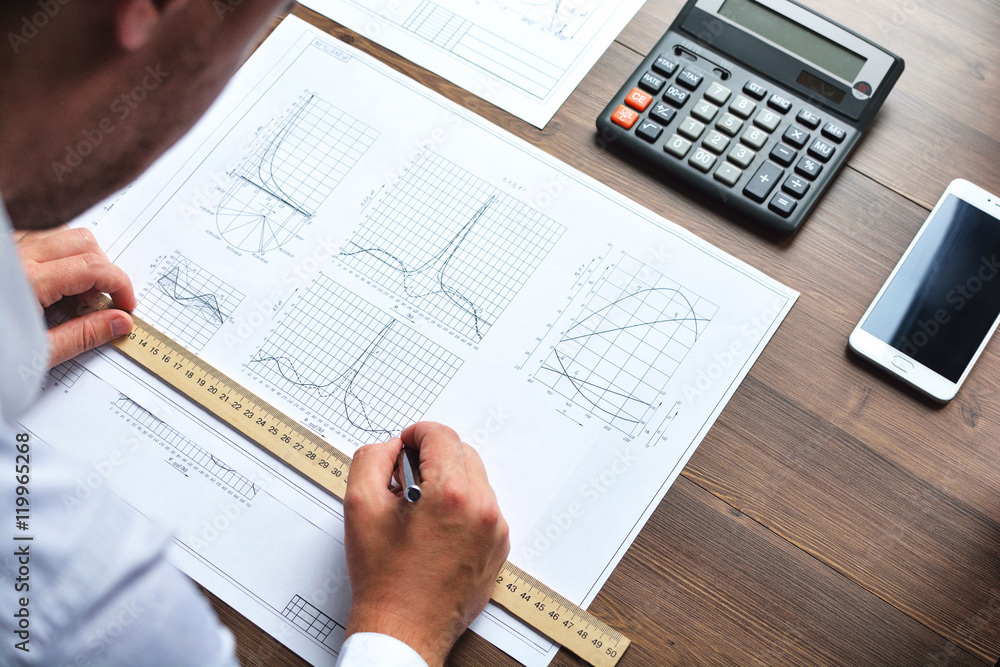 Mechanical engineer at work. Technical drawings. Paper with technical ...