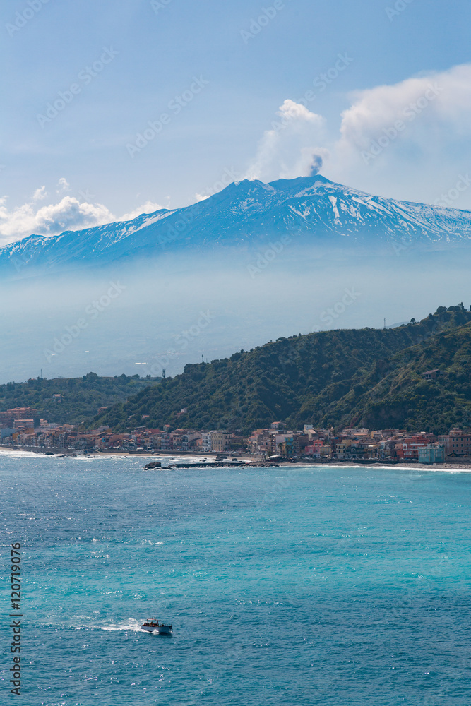 Small boat passing the awe inspiring Mount Etna, and Europe's tallest ...