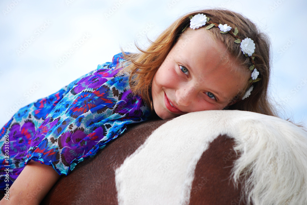 YOUNG GIRL LYING ON THE BACK OF TRAKEHNER PAINT HORSE Stock Photo ...
