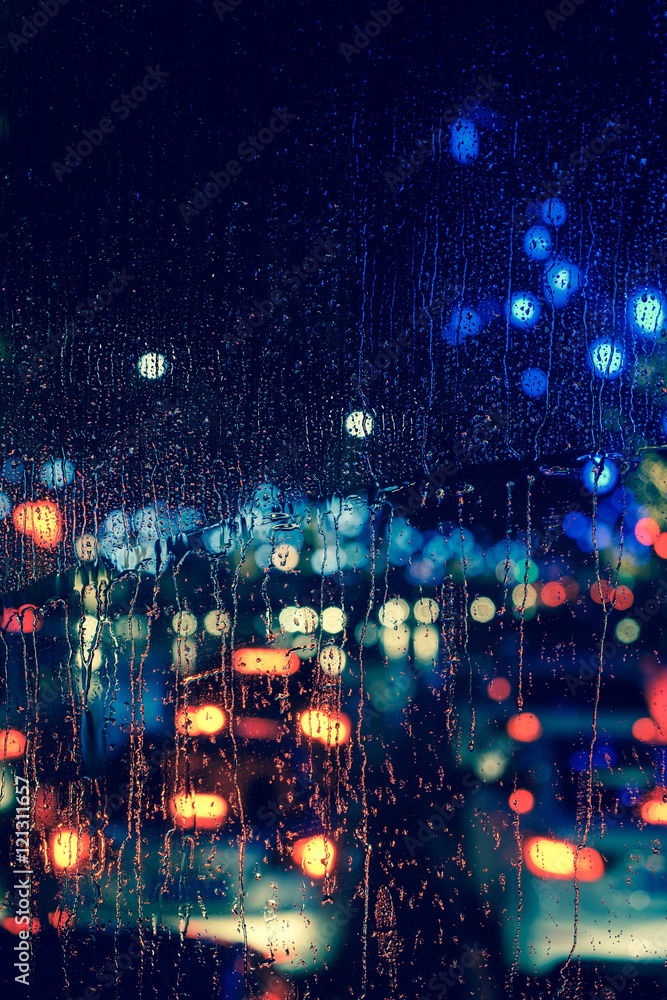 City view through a window on a rainy night,Rain drops on window with ...