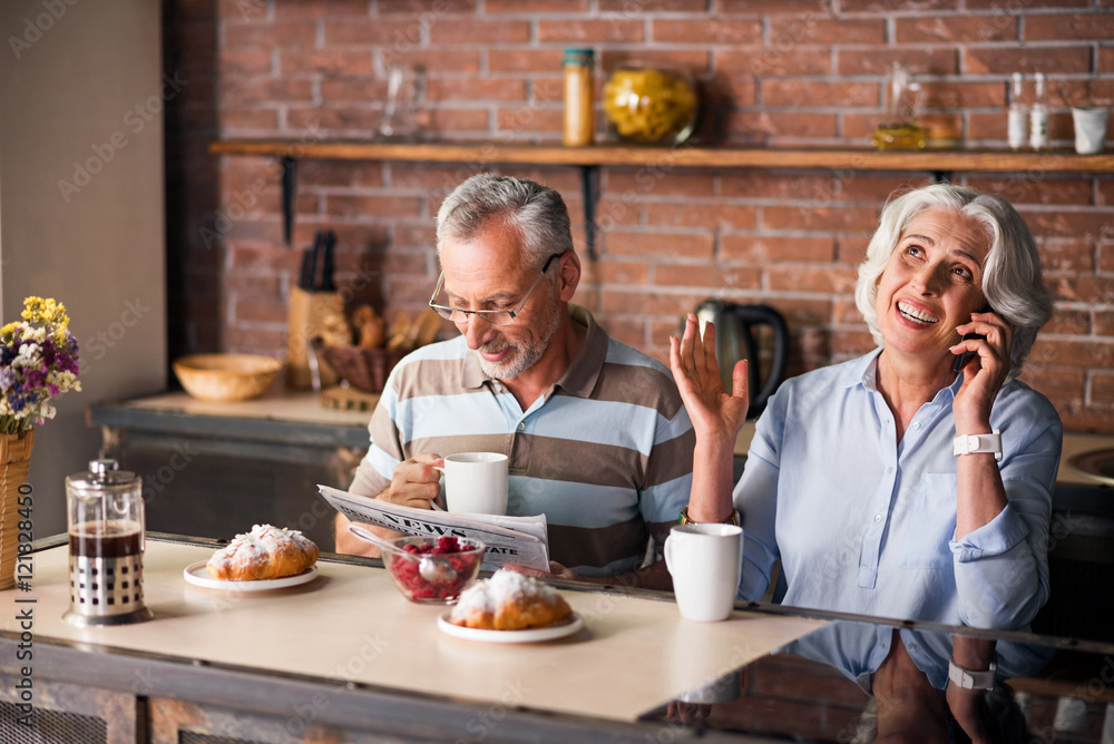 Joyful senior citizen couple drinking coffee together in the kitchen ...