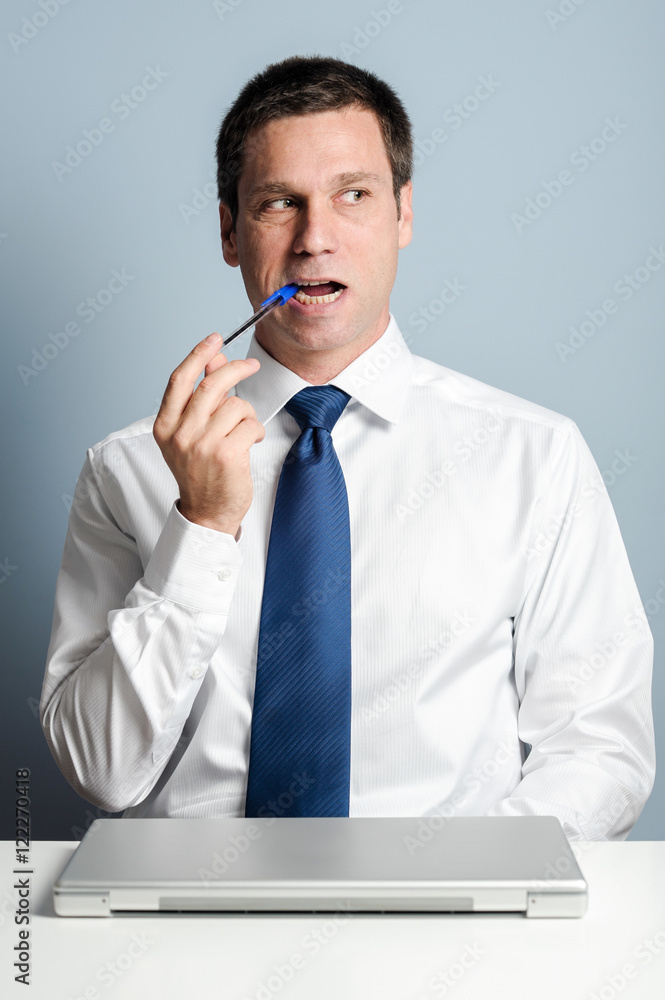 Uncertain man male businessman sitting at desk in shirt and tie with ...